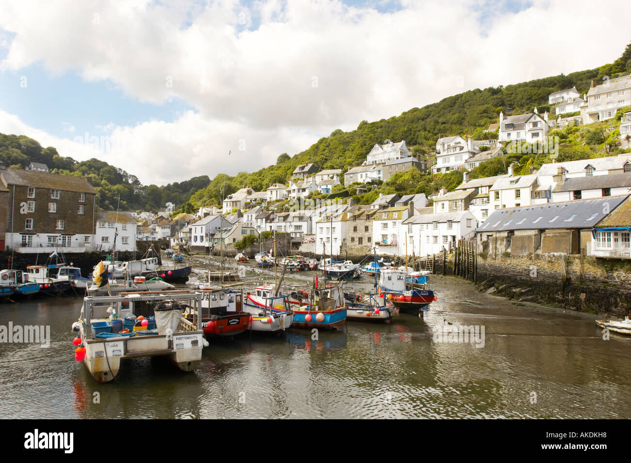 Whitewashed houses overlooking Polperro Harbour at low tide exposing ...