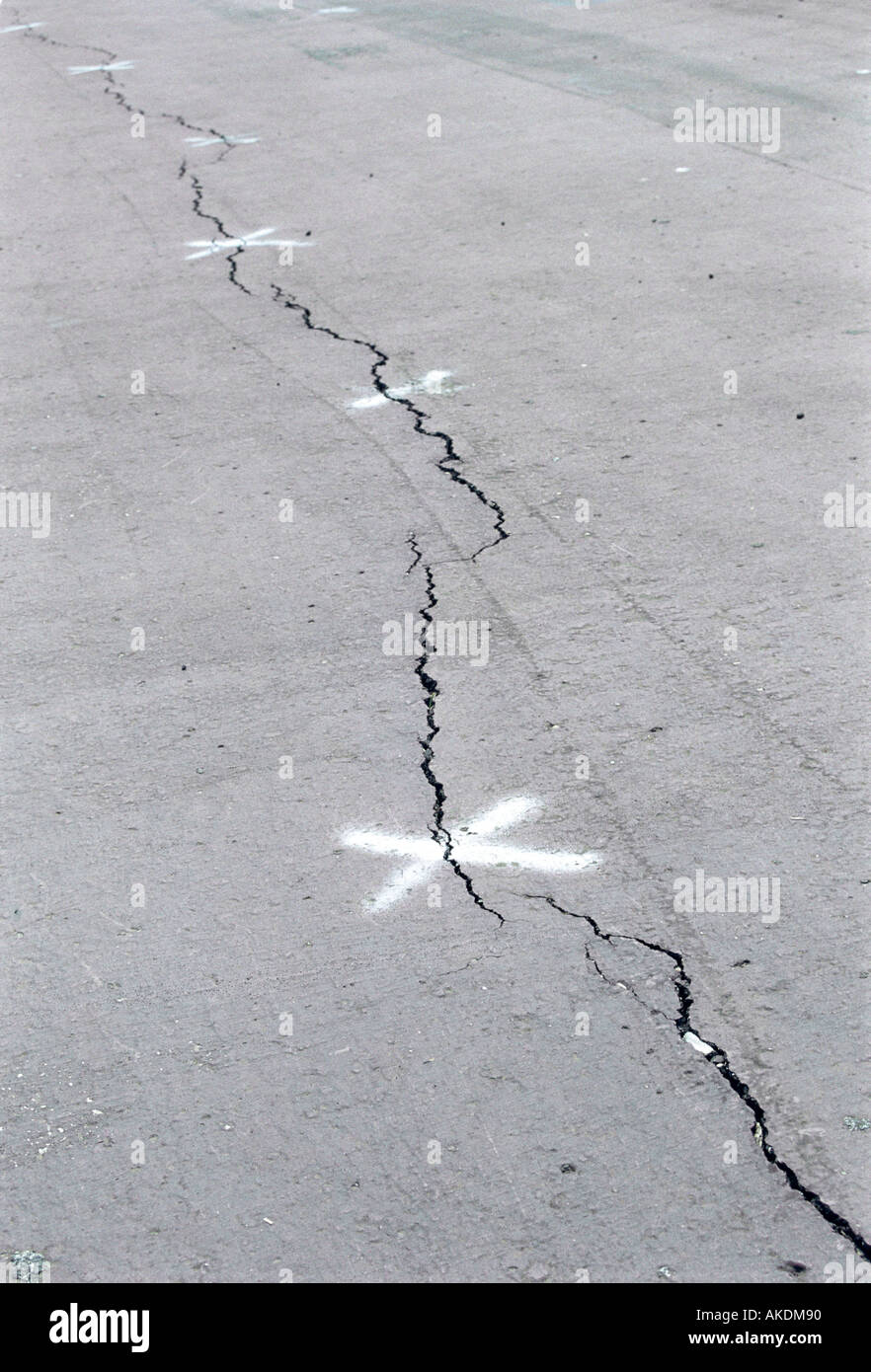 white paint crosses marking cracks in road surface Stock Photo - Alamy