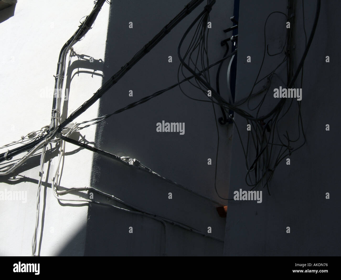 tangled wiring connections on white wash wall Stock Photo - Alamy