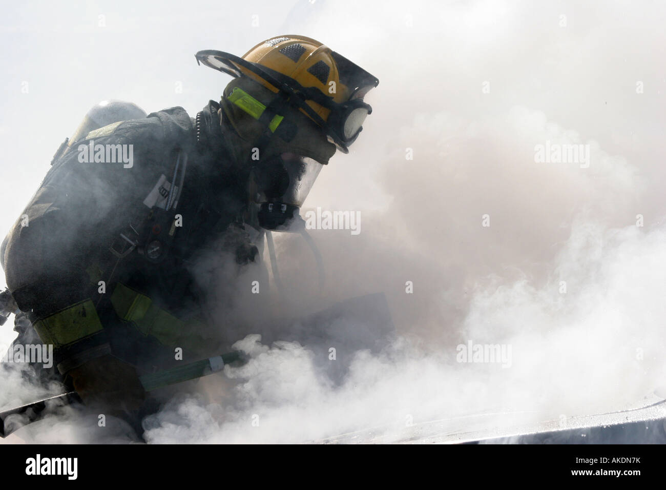 A firefighter with an ax at the scene of a car fire Stock Photo - Alamy