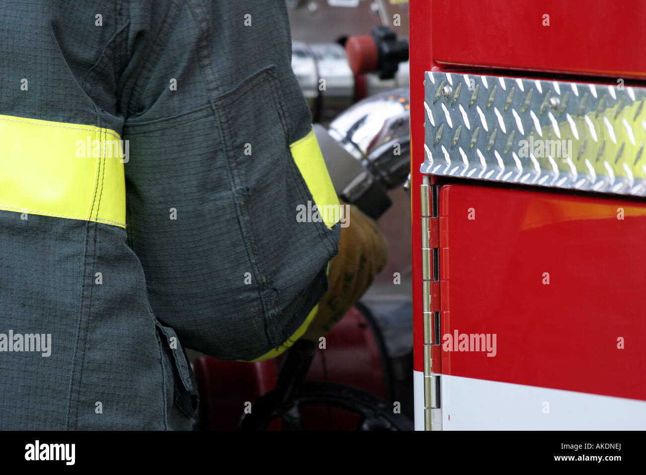 A firefighter making the connection of a supply hoseline to the pumper ...