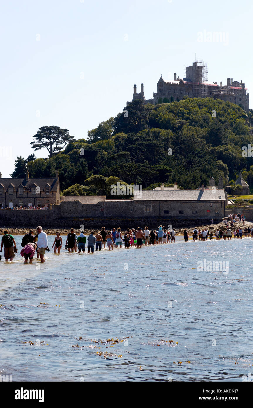 Visitors wade across a causeway, submerged in seawater to and from the ...
