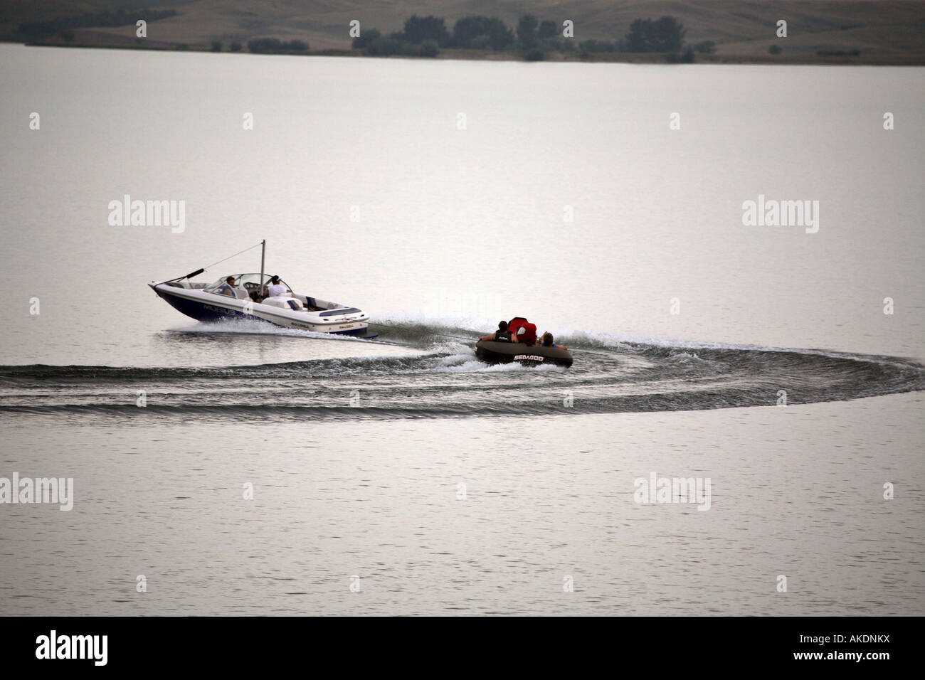 Spped boat pulling raft Stock Photo - Alamy
