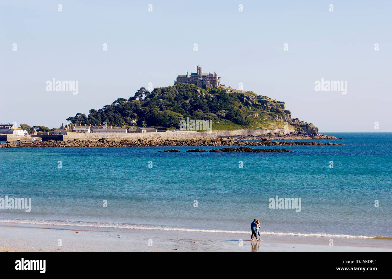 Tourists walking on the beach at Marazion with St Michael's Mount in ...