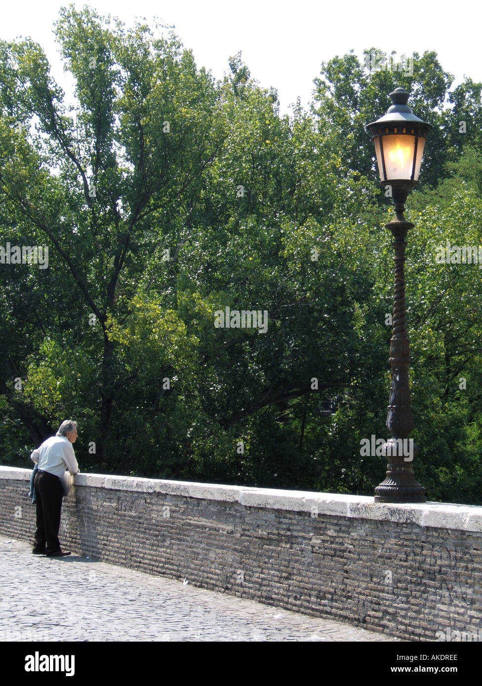 man on bridge with street lamp post on during the day Stock Photo - Alamy