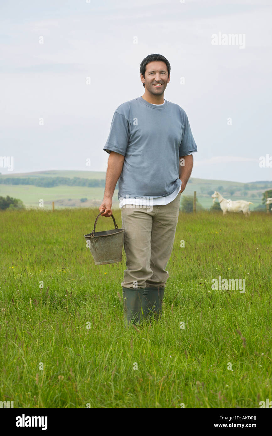 Man holding bucket in field, portrait Stock Photo - Alamy