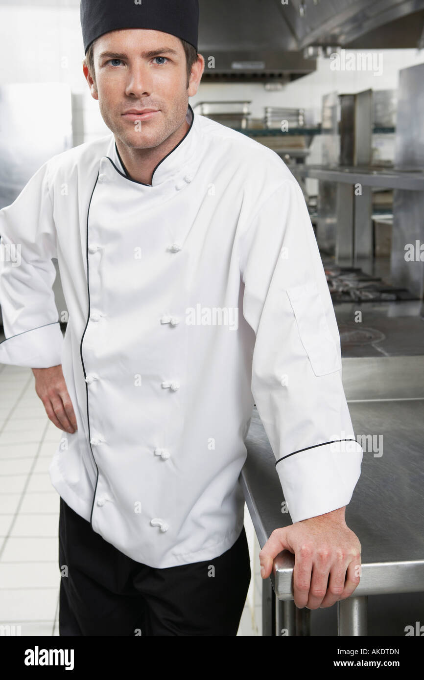 Male chef with hand on hip in kitchen, portrait Stock Photo - Alamy