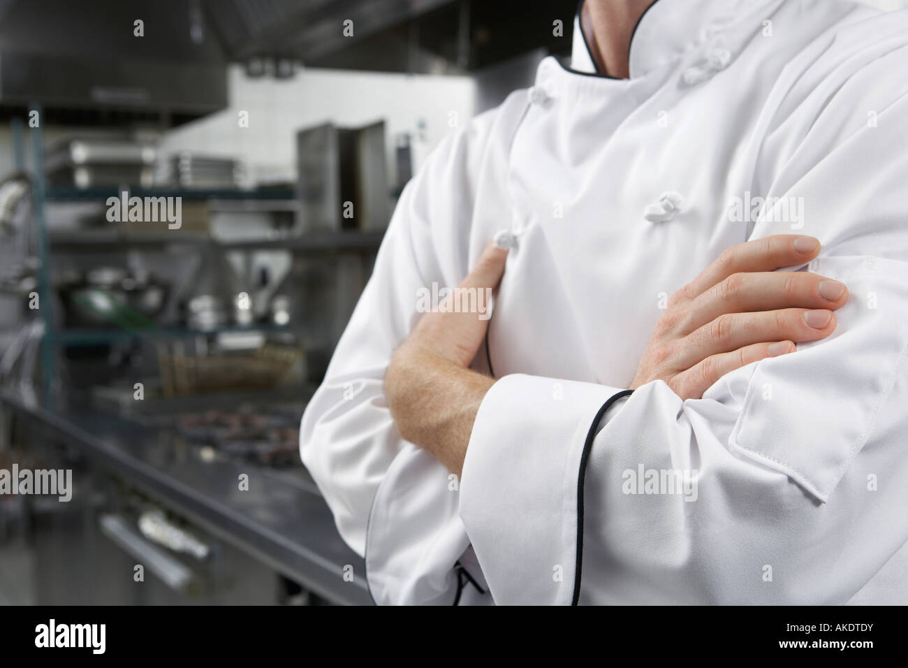 Male chef with arms crossed in kitchen, mid section Stock Photo - Alamy