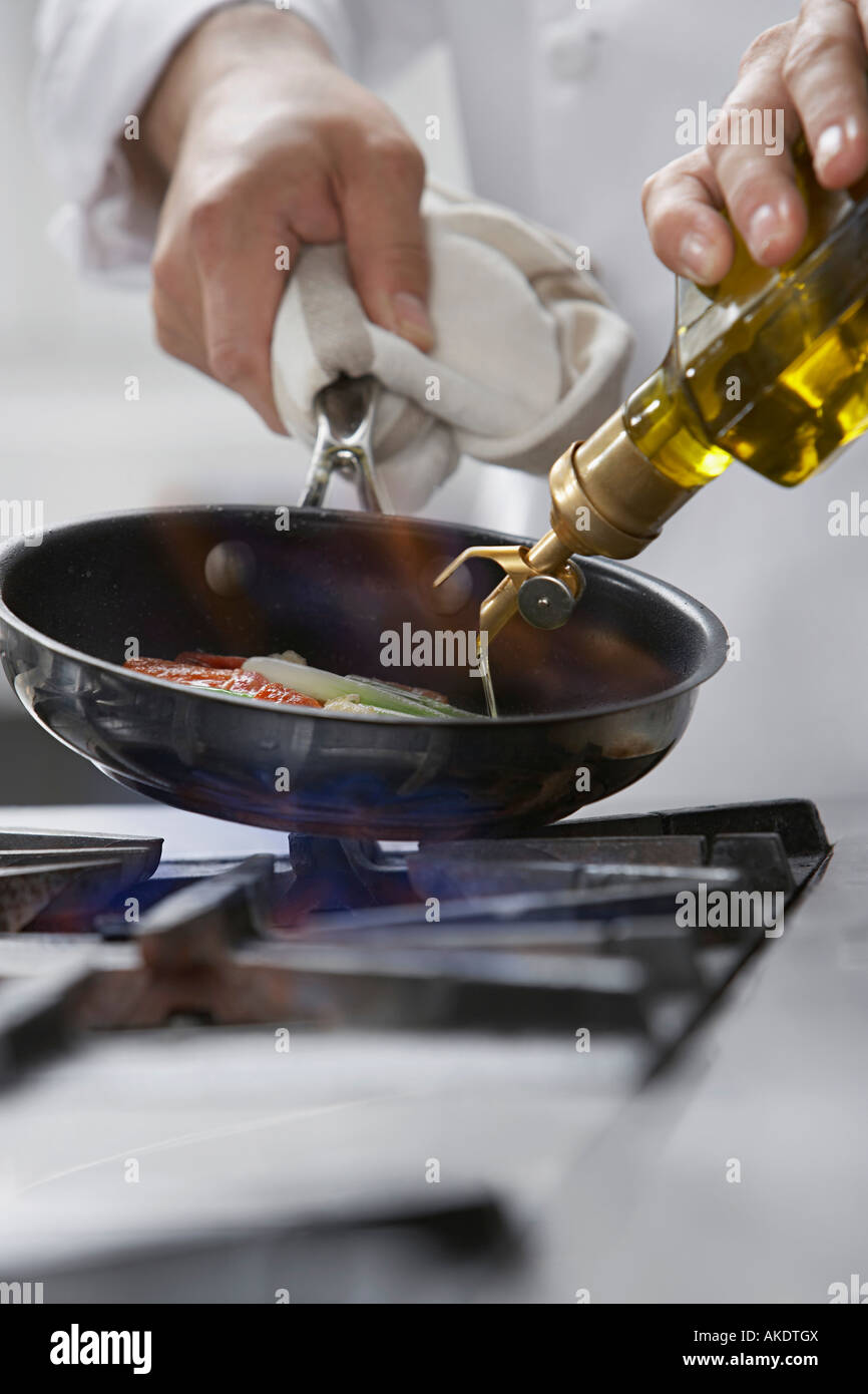 Chef cooking food in frying pan, close-up Stock Photo - Alamy
