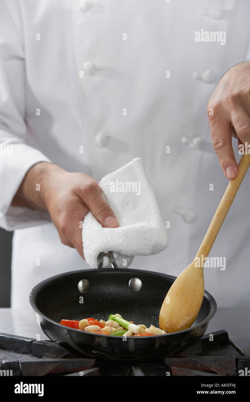 Chef cooking food in frying pan, mid-section Stock Photo - Alamy
