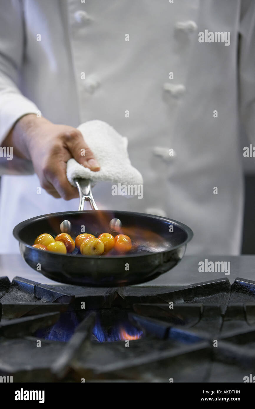 Chef cooking food in frying pan, mid-section Stock Photo - Alamy