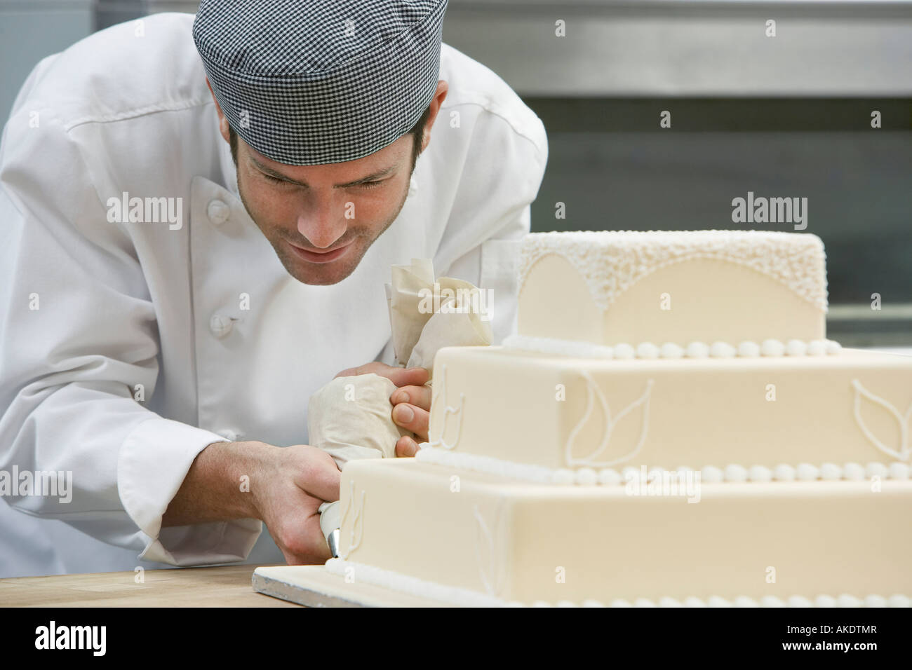 Male chef icing wedding cake in kitchen Stock Photo - Alamy