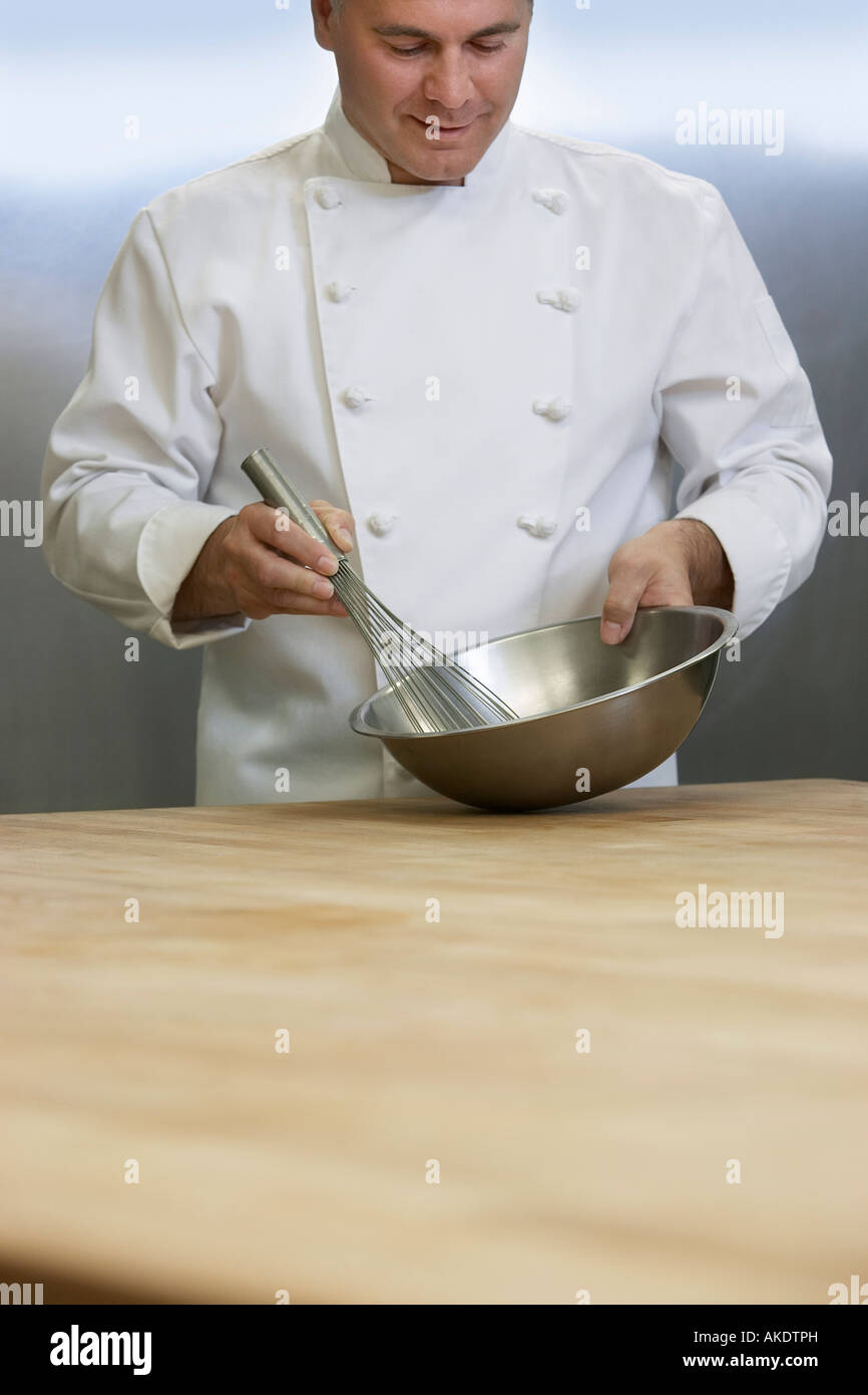Male chef mixing ingredients using whisk in kitchen Stock Photo - Alamy
