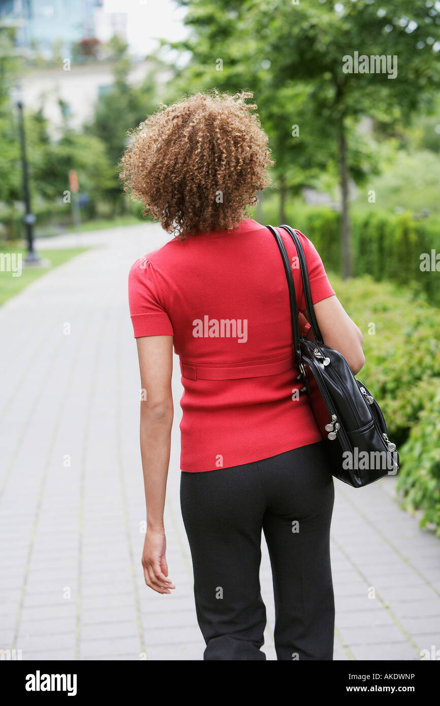 Back view curly woman walking hi-res stock photography and images - Alamy