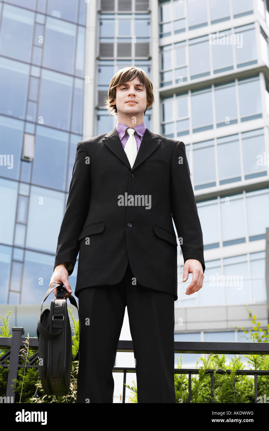 Business man holding briefcase, outside office, portrait Stock Photo ...