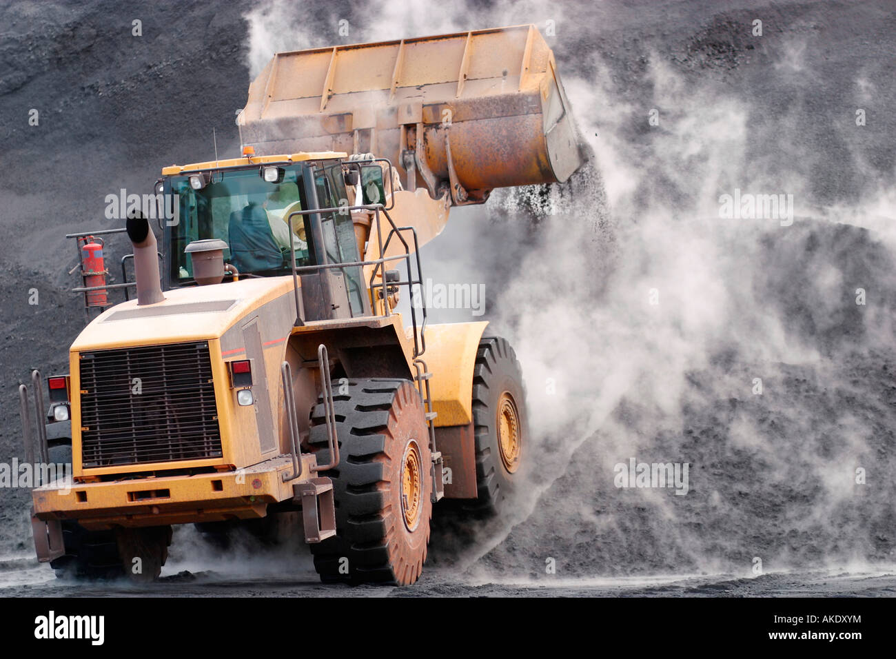 Front loader dumping mineral material on heap Stock Photo - Alamy