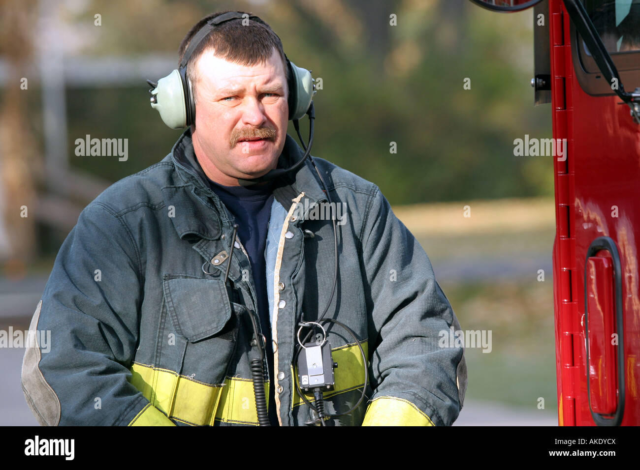 A MPO firefighter at the controls of a pumper engine listening to ...