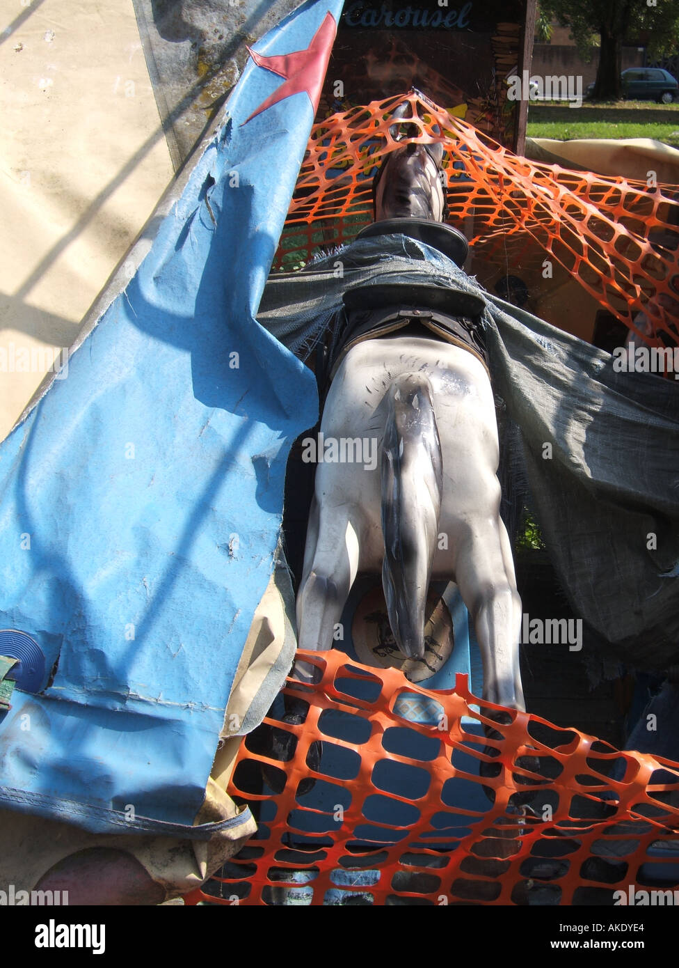 horse ride model covered with sheeting in run down fair ground Stock ...