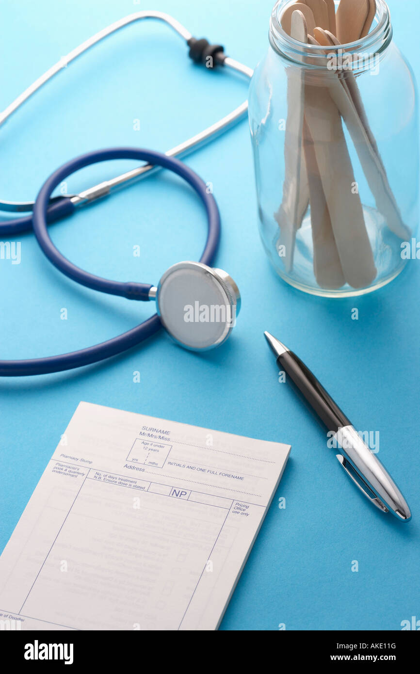 Stethoscope, pen, notepad and jar of sticks on doctors table Stock ...