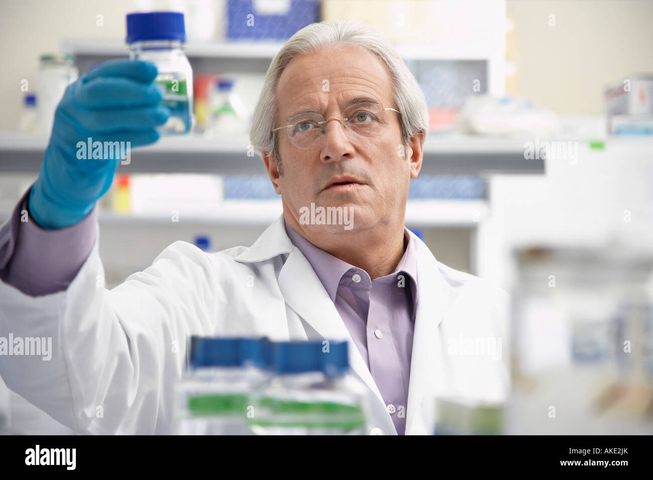 Scientist looking at specimen bottle in laboratory Stock Photo - Alamy