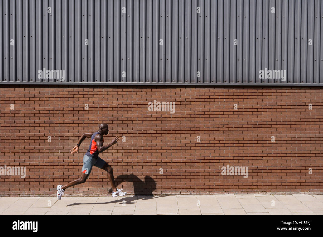 Man running past brick wall Stock Photo - Alamy