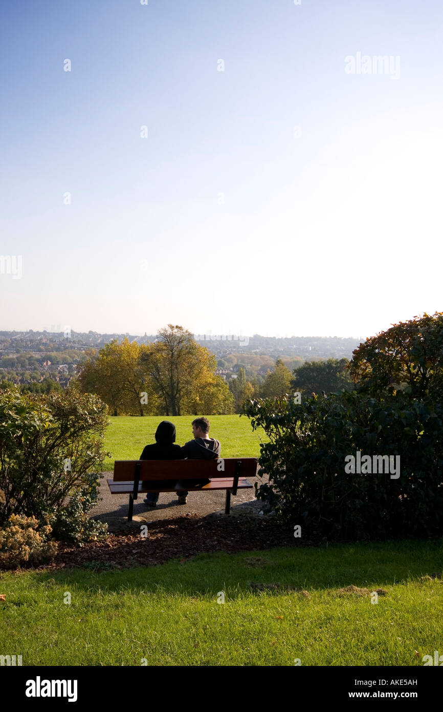 Silhouette of couple on park bench outside Alexandra Palace, London ...