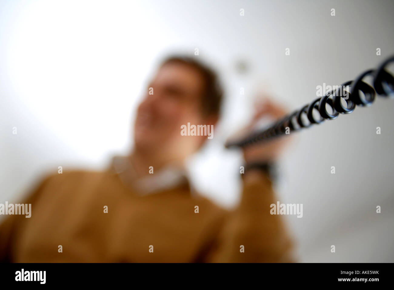 Man making telephone call with focus on the telephone cable Stock Photo ...
