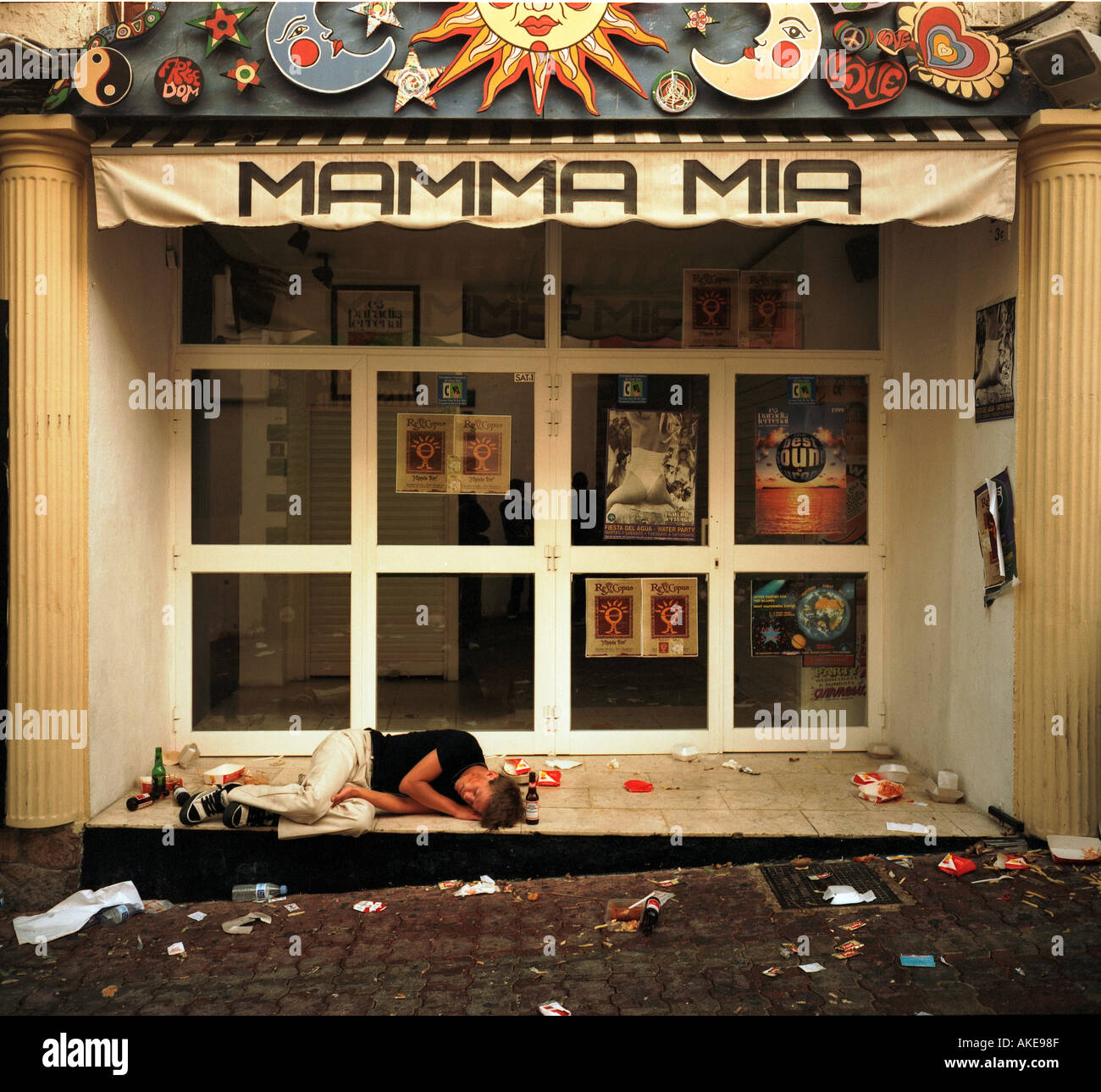 A drunk young man collapsed and sleeping on the street outside a bar in ...