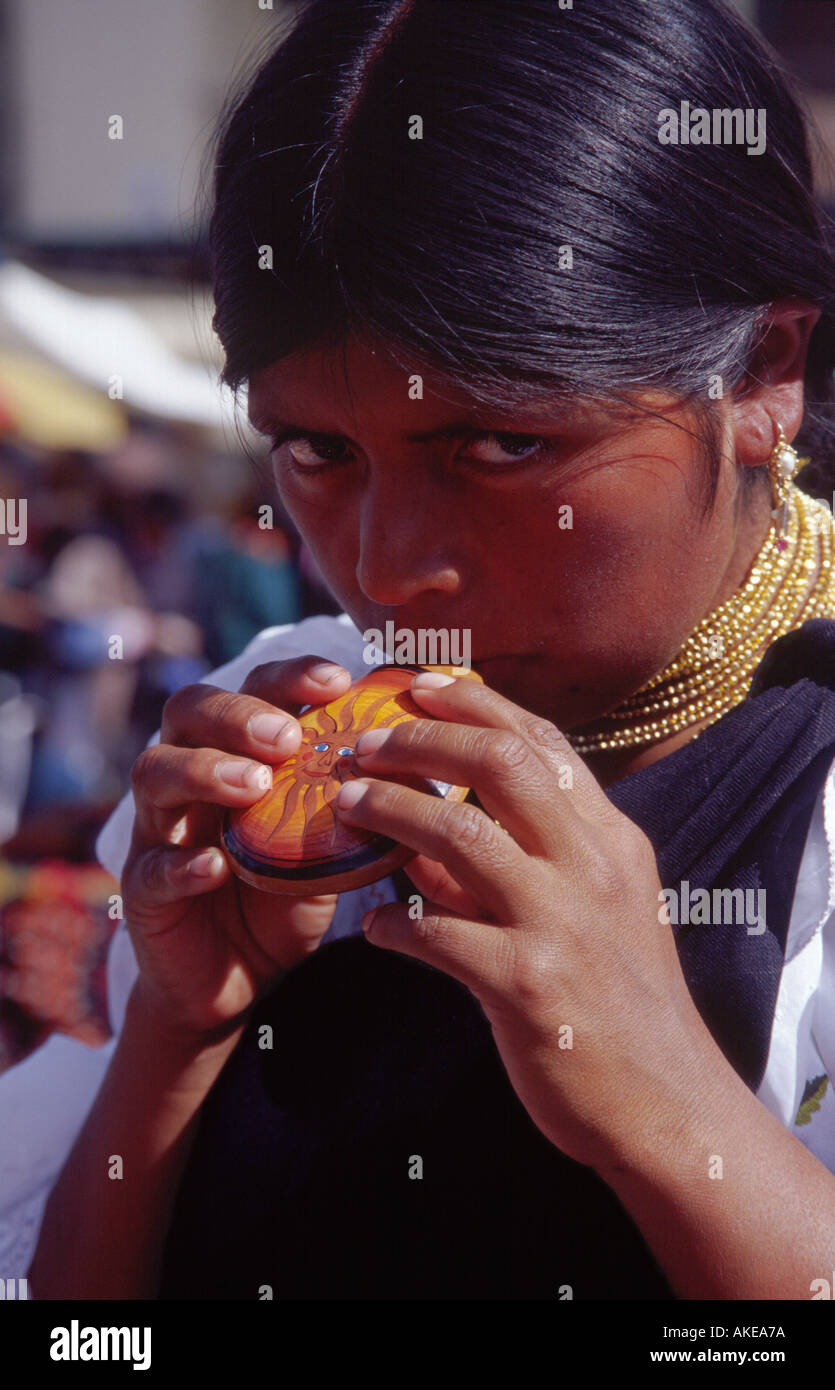 Indigenous girl in Otavalo market demonstrating pottery musical ...