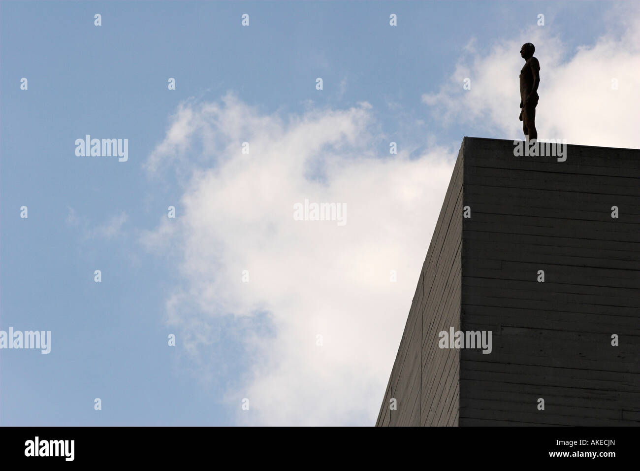 Antony Gormley sculpture, figure standing on edge of building roof ...