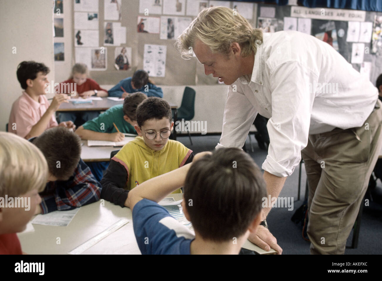 Secondary classroom with teacher assisting pupils Stock Photo - Alamy