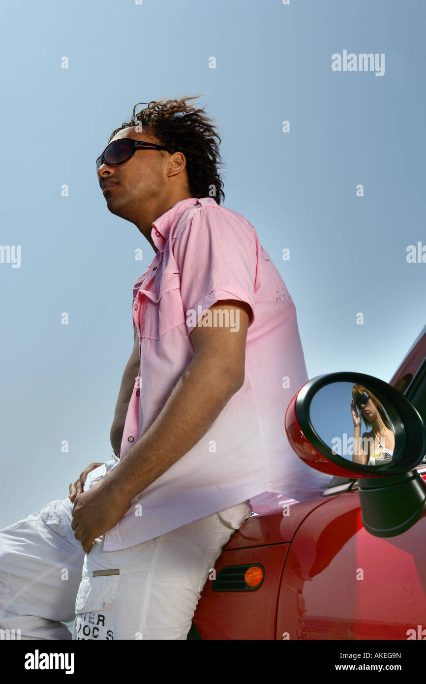 Young man standing by a red car Stock Photo - Alamy