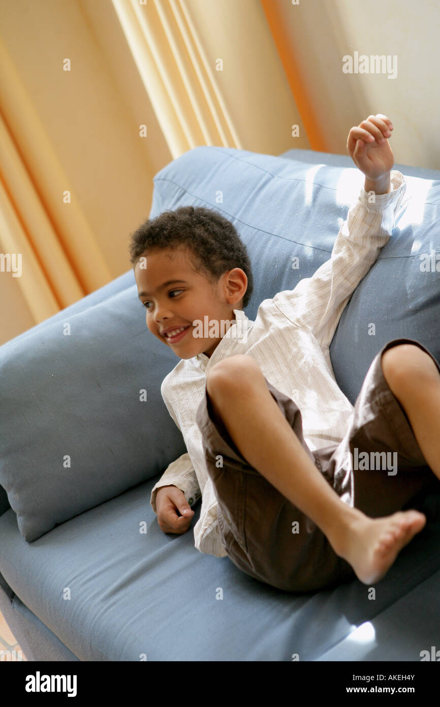 metis child having fun on the couch Stock Photo - Alamy