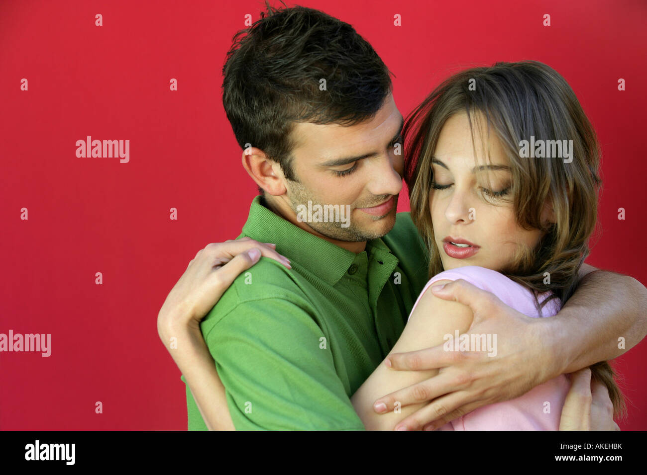 young couple in red background Stock Photo - Alamy