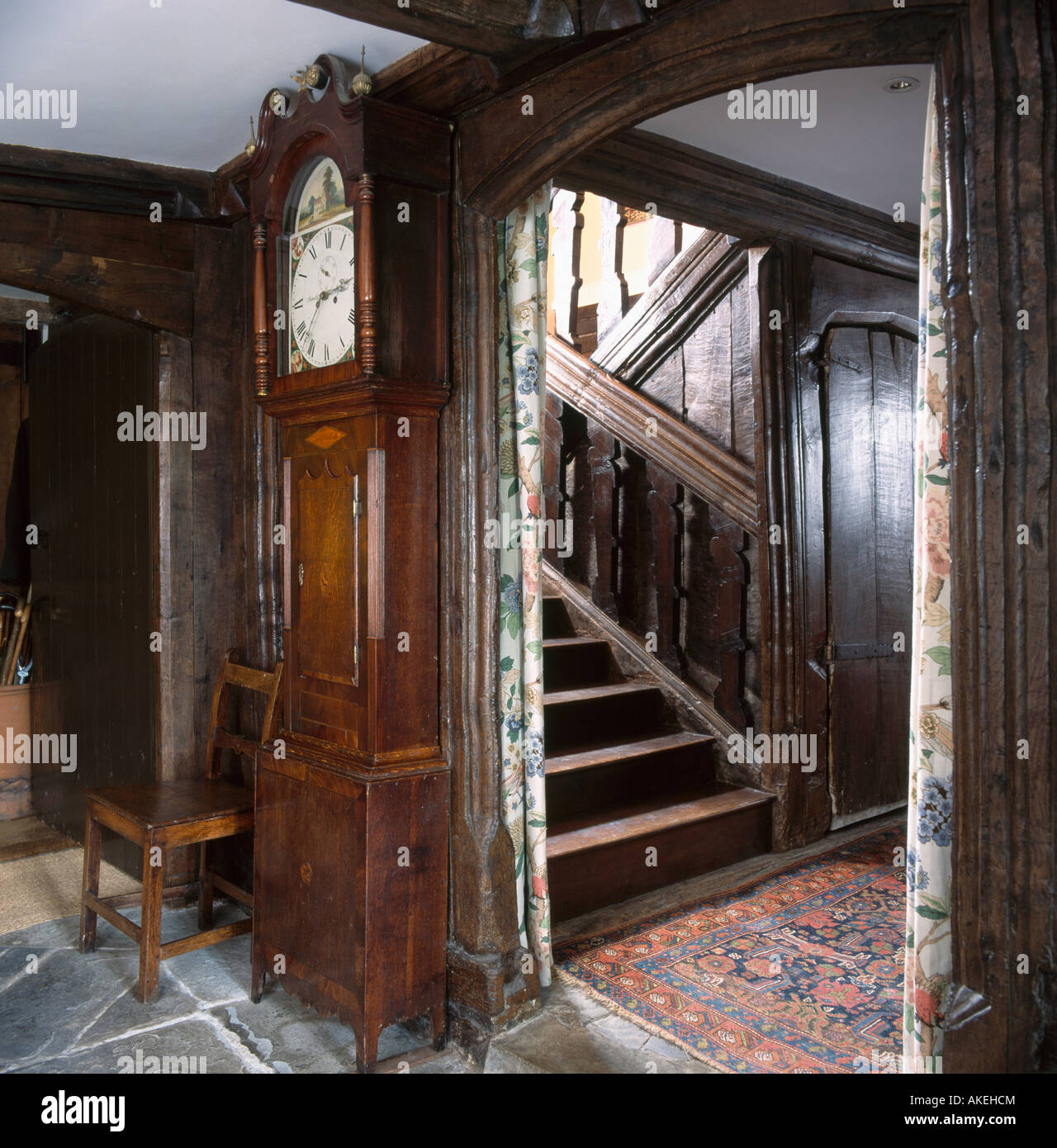 Antique longcase clock beside interior doorway in traditional country ...