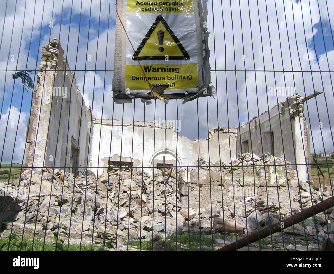 warning sign by building being demolished Stock Photo - Alamy