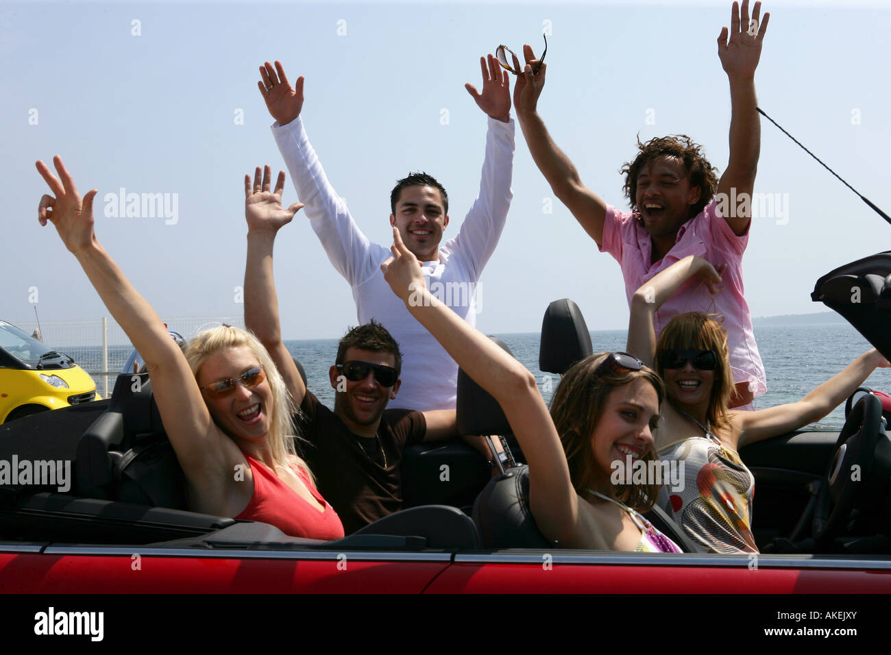 Friends in a red convertible car Stock Photo - Alamy
