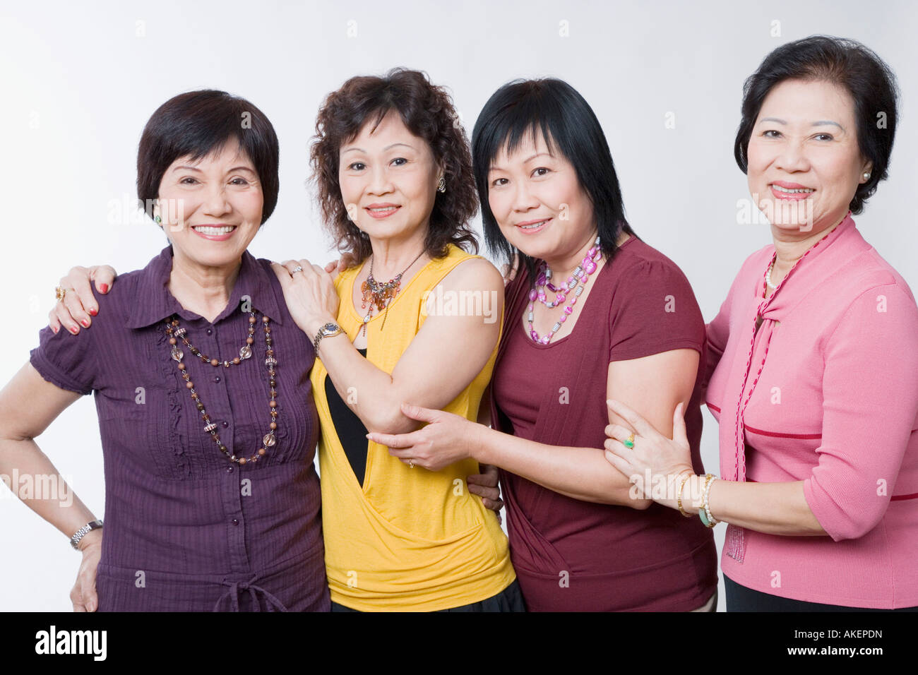 Portrait of three senior women and a mature woman standing together and ...