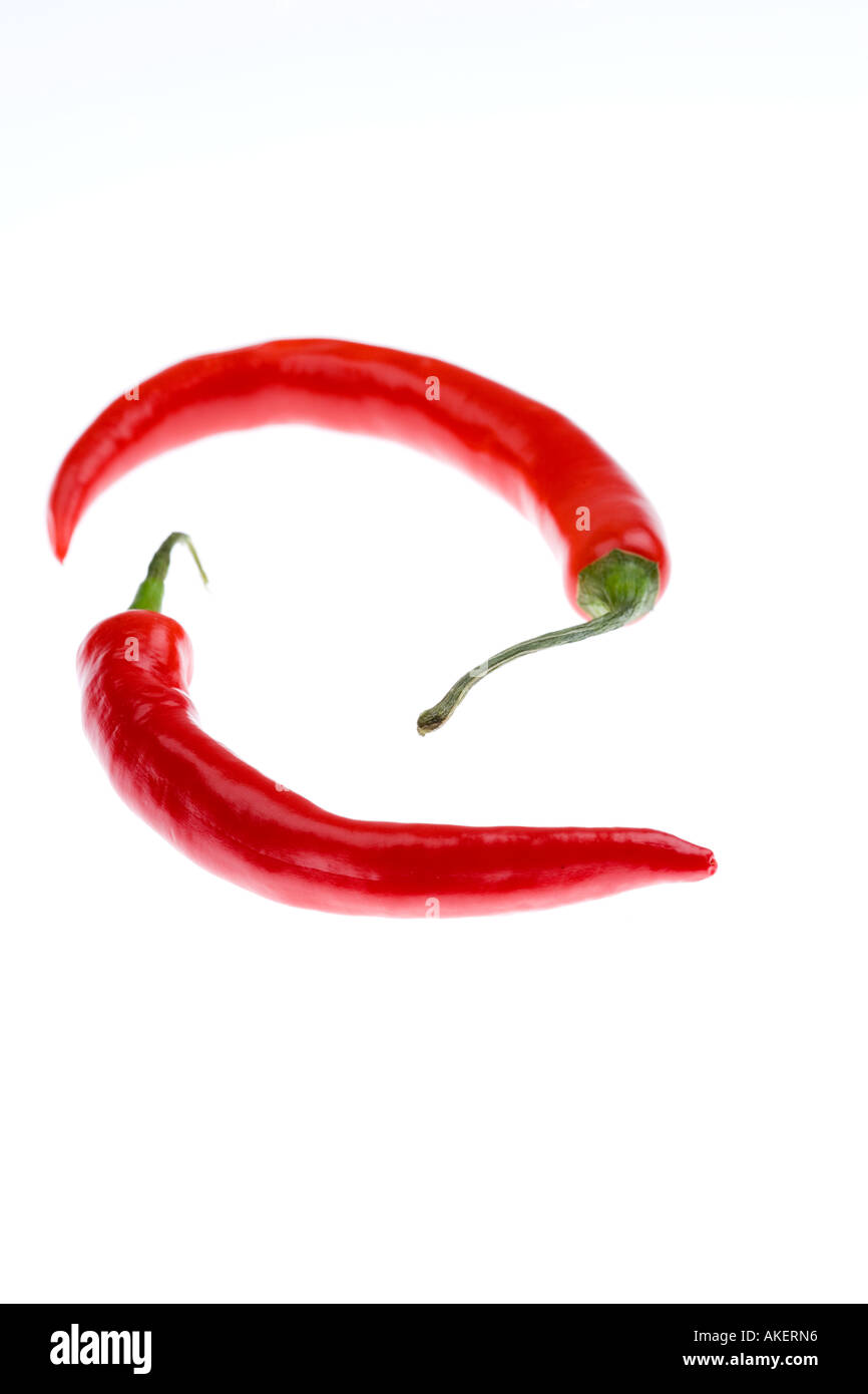 Two Hot red chilli chillis chili placed besides one another on white ...
