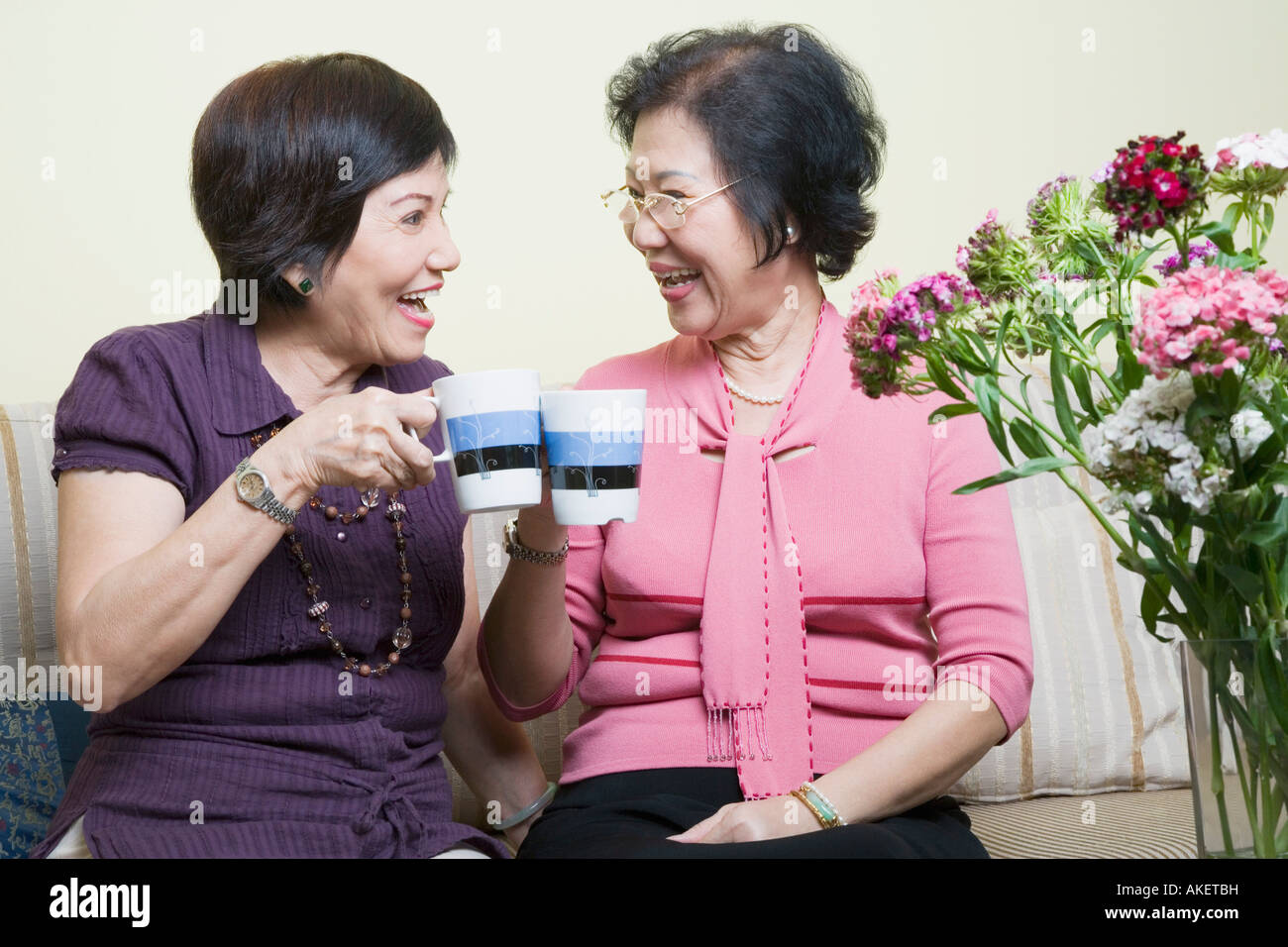 Close-up of two senior women toasting with cups and laughing Stock ...