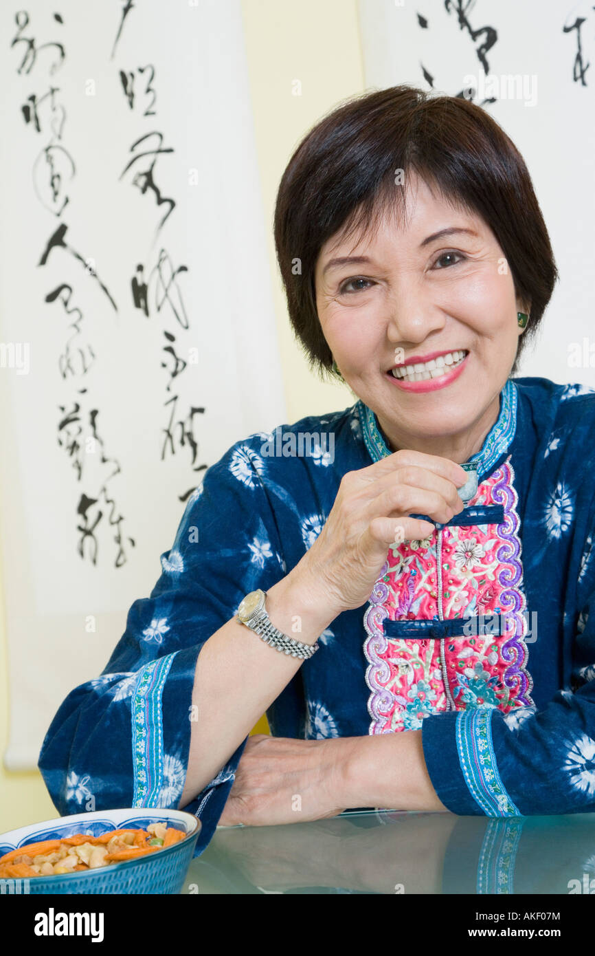 Portrait of a senior woman sitting at a table and smiling Stock Photo ...