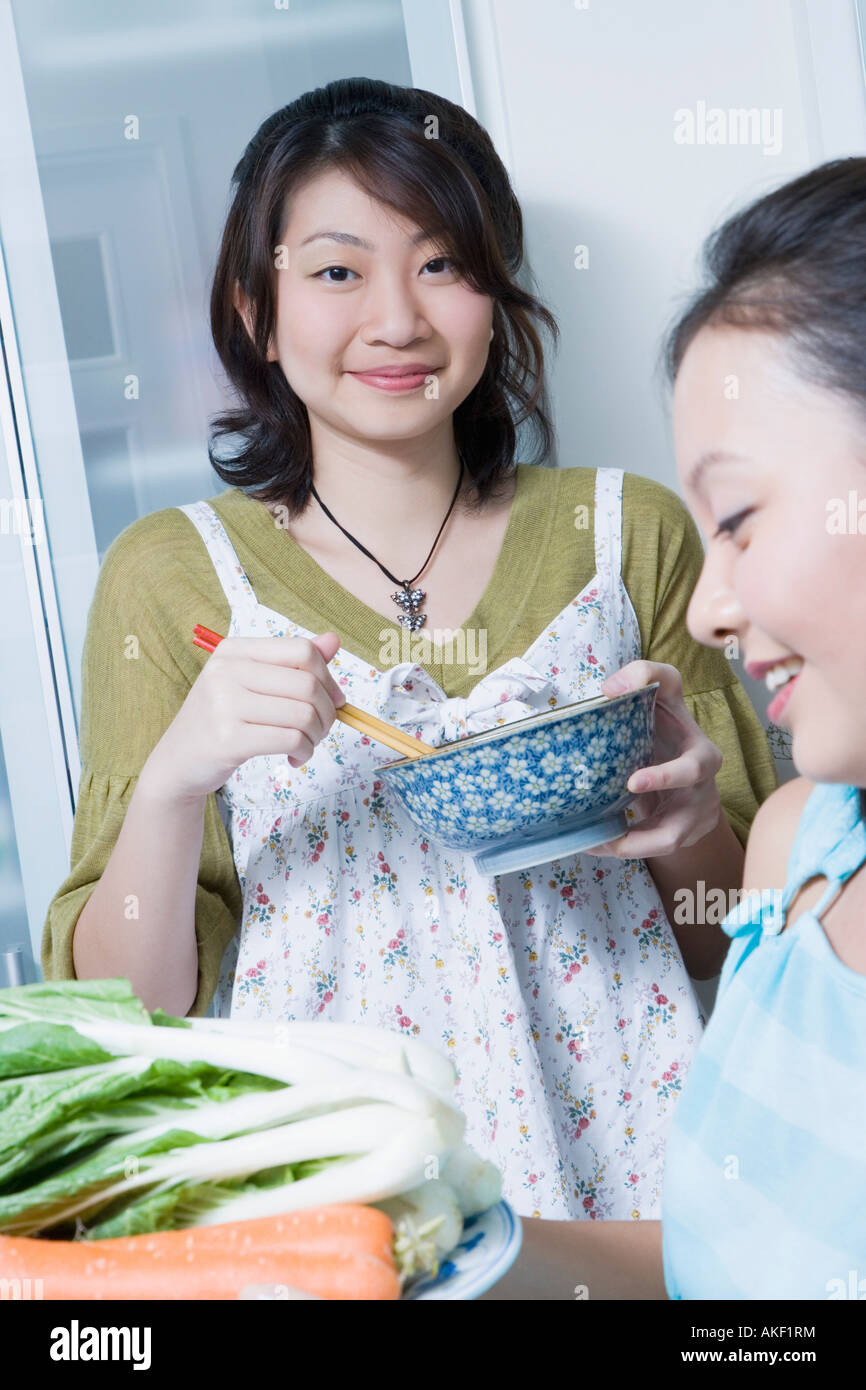 Two young women preparing food in a kitchen Stock Photo - Alamy