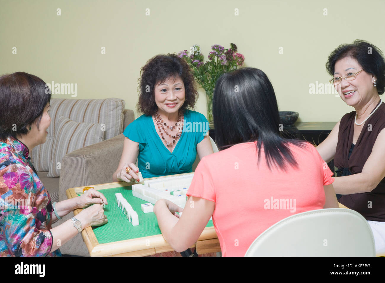 Three senior women and a mature woman playing mahjong Stock Photo - Alamy