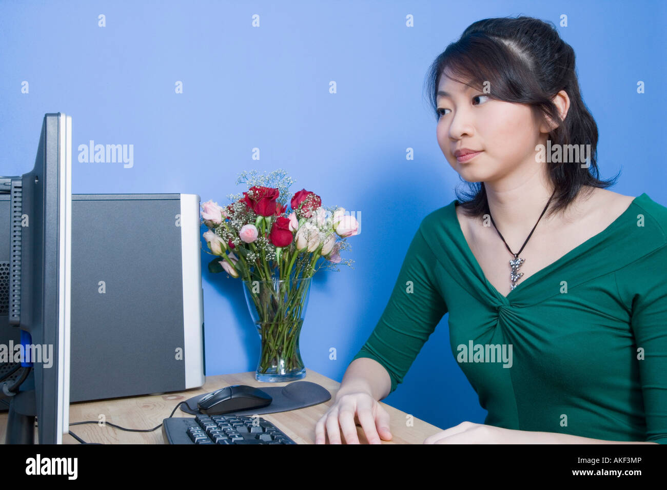 Side profile of a young woman sitting in front of a desktop PC Stock ...