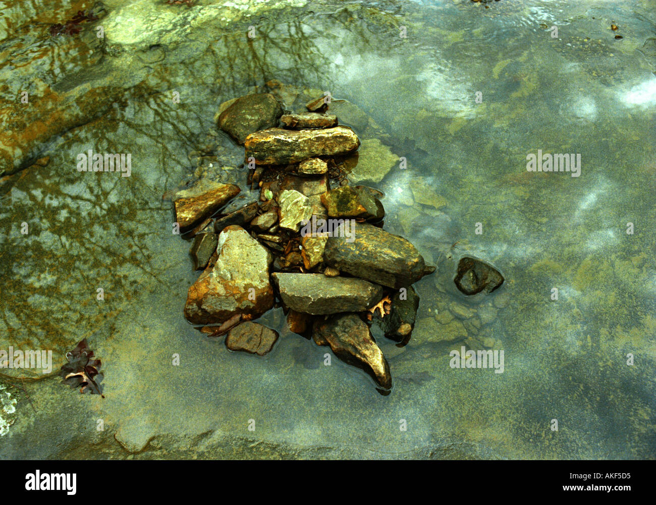Pile of rocks in reflection of a pool of water Stock Photo - Alamy