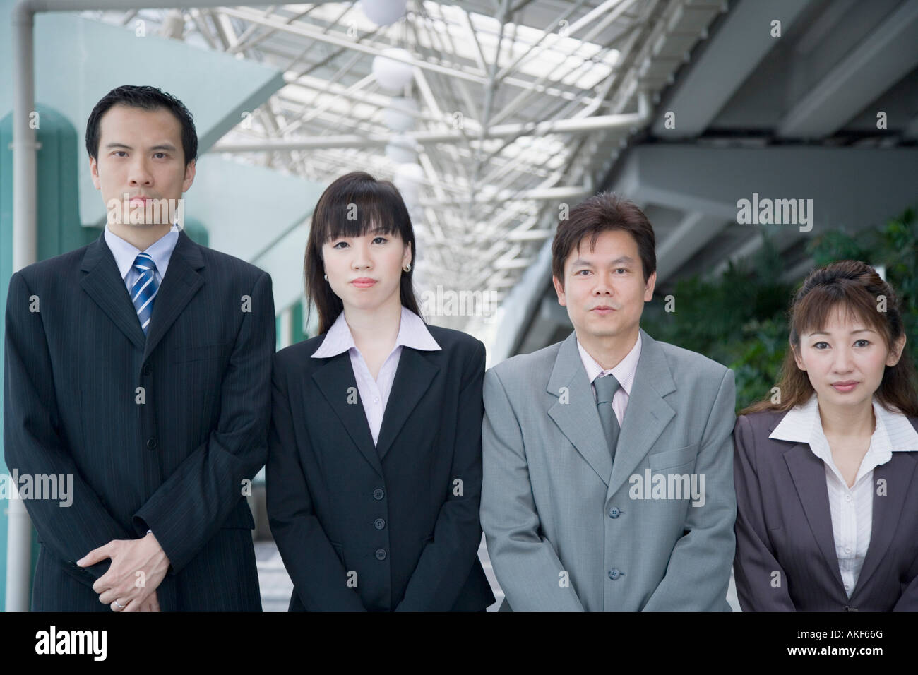 Portrait of four business executives standing side by side Stock Photo ...
