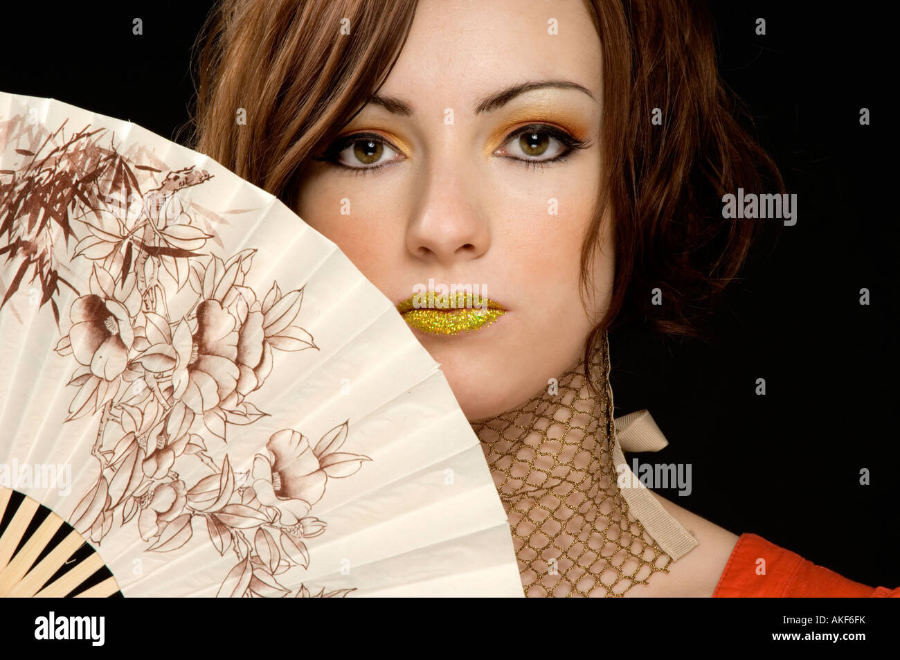 woman holding a paper fan Stock Photo - Alamy