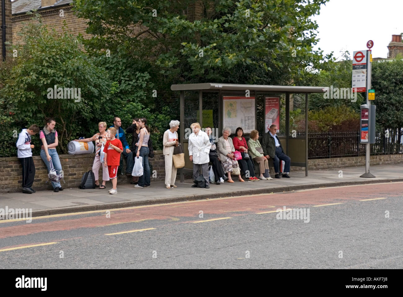 People waiting patiently and calmly in a queue for a bus to arrive ...