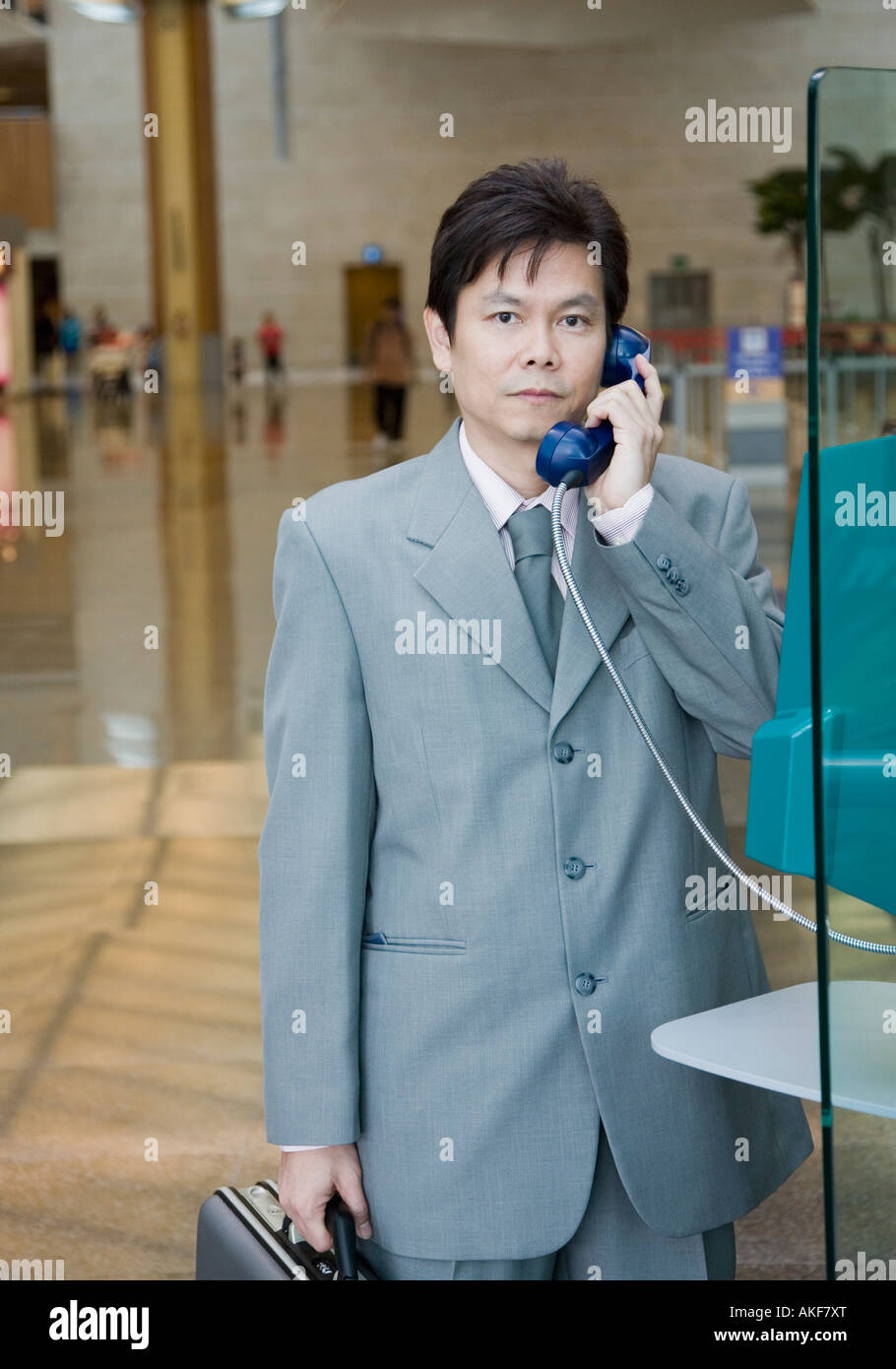 Portrait of a businessman using a pay phone Stock Photo - Alamy
