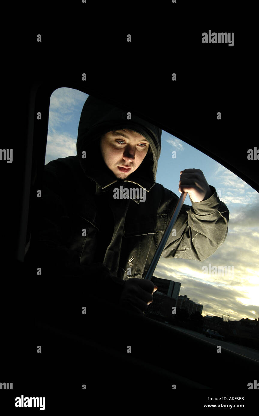 car thief breaking in to a new modern car Stock Photo - Alamy
